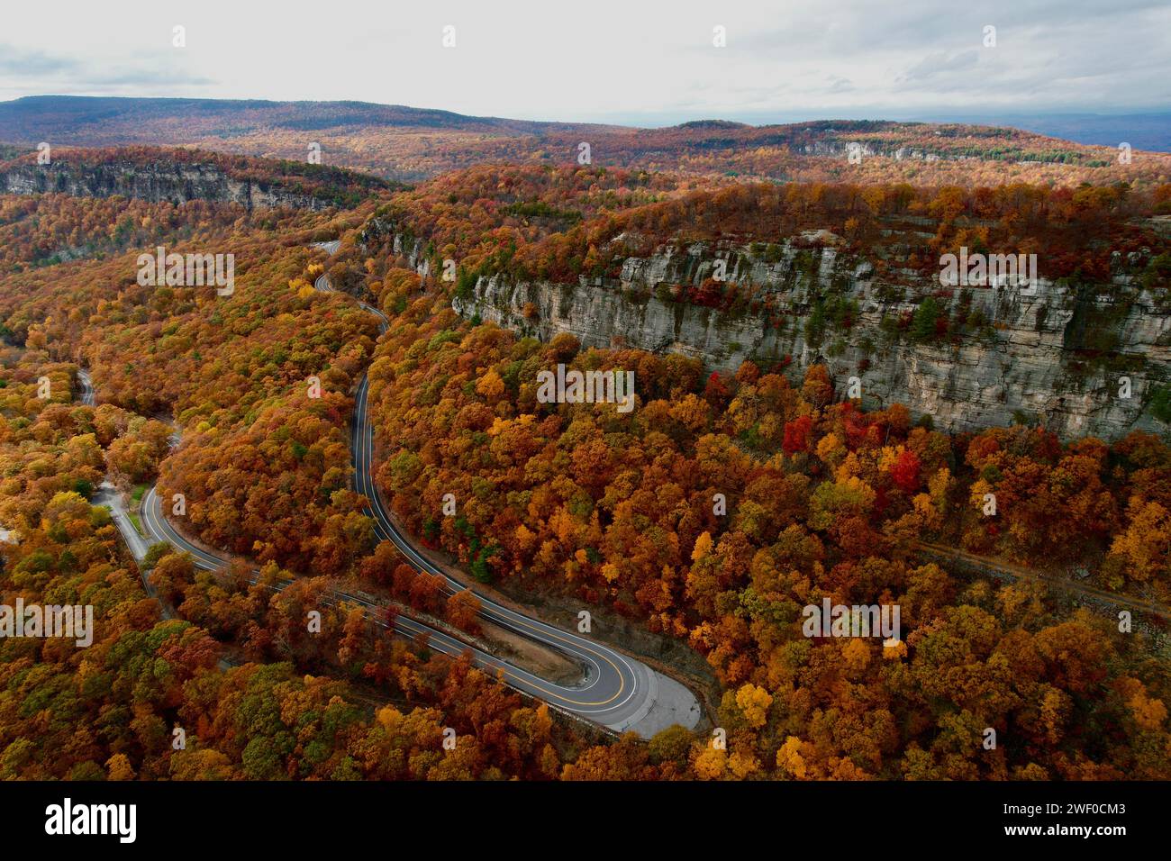 A scenic mountainous road winding between towering cliff Stock Photo ...