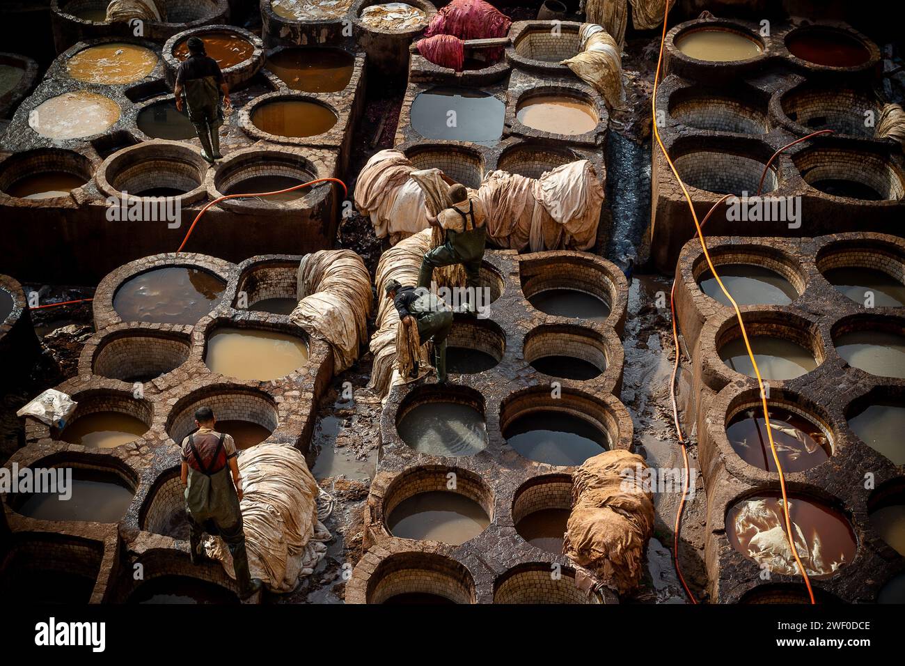Workers assembling a clay furnace filled with clay and water: Chouara ...