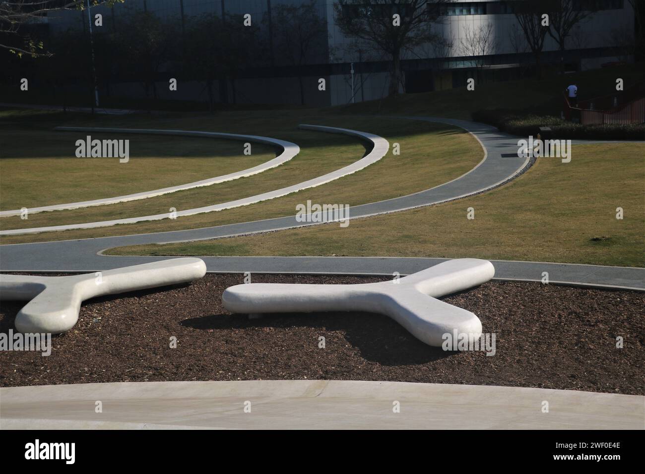 Curved park benches line the ground, facing an office building Stock ...