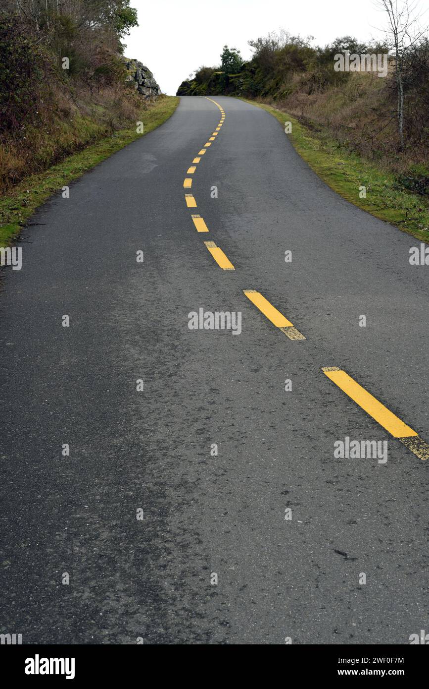 A vertical view of an uphill path divided by a yellow broken line Stock ...