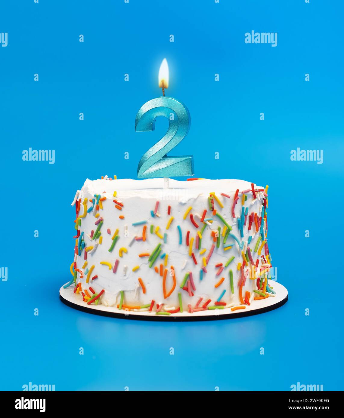 2 shaped candle light on happy birthday cake on blue Stock Photo - Alamy