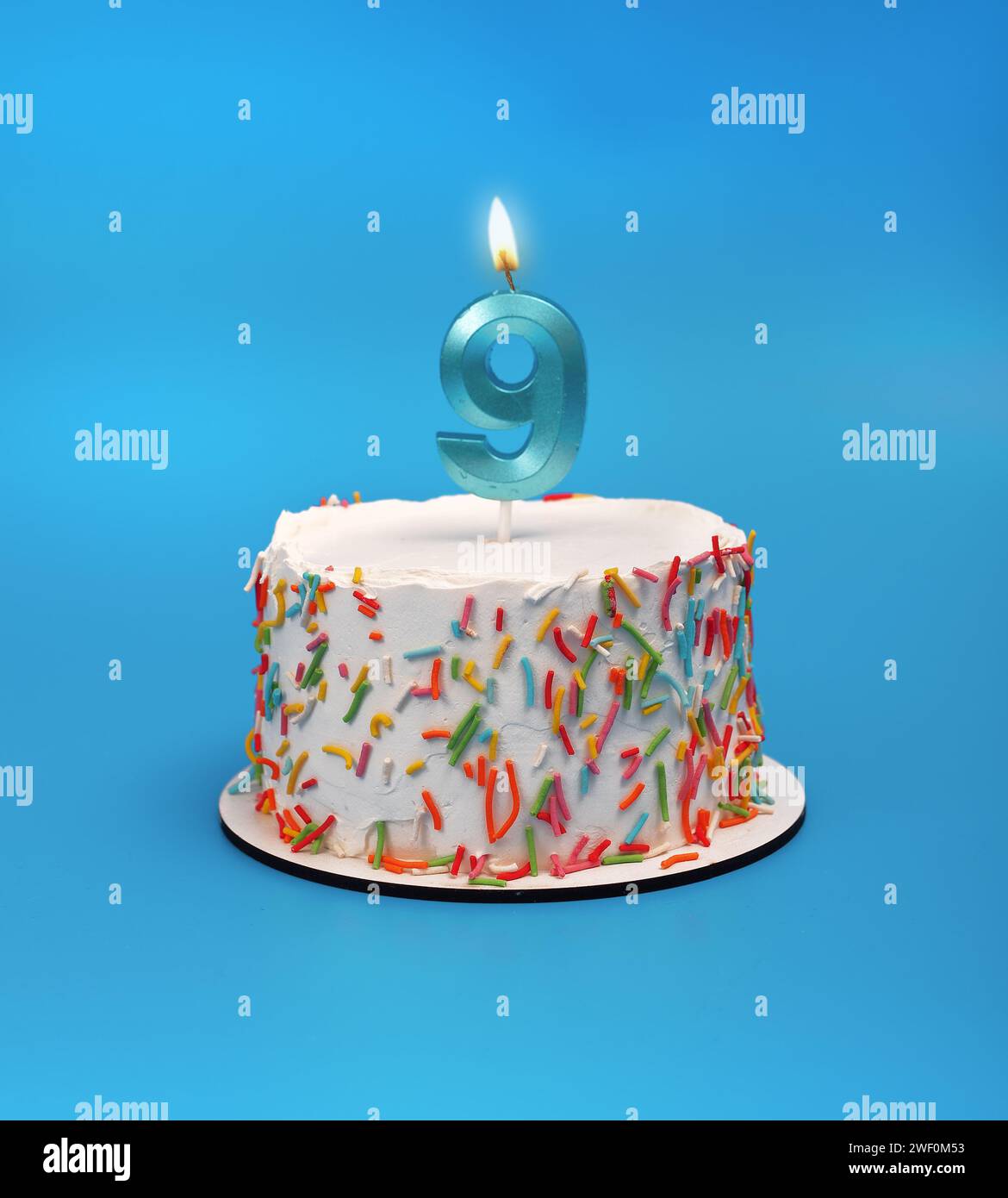 9 shaped candle light on happy birthday cake on blue Stock Photo - Alamy