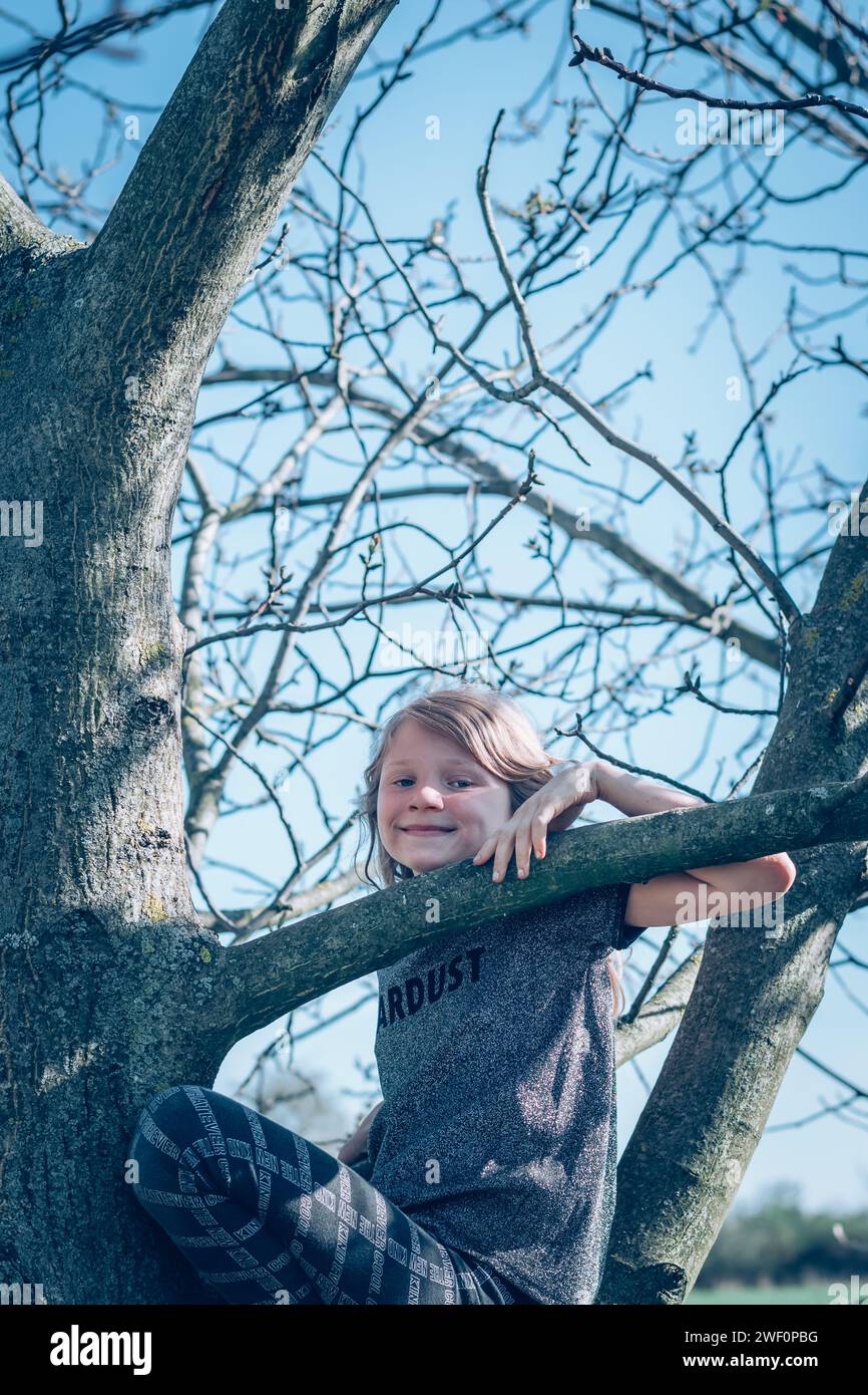 adorable girl with long blond hair among tree branches Stock Photo - Alamy