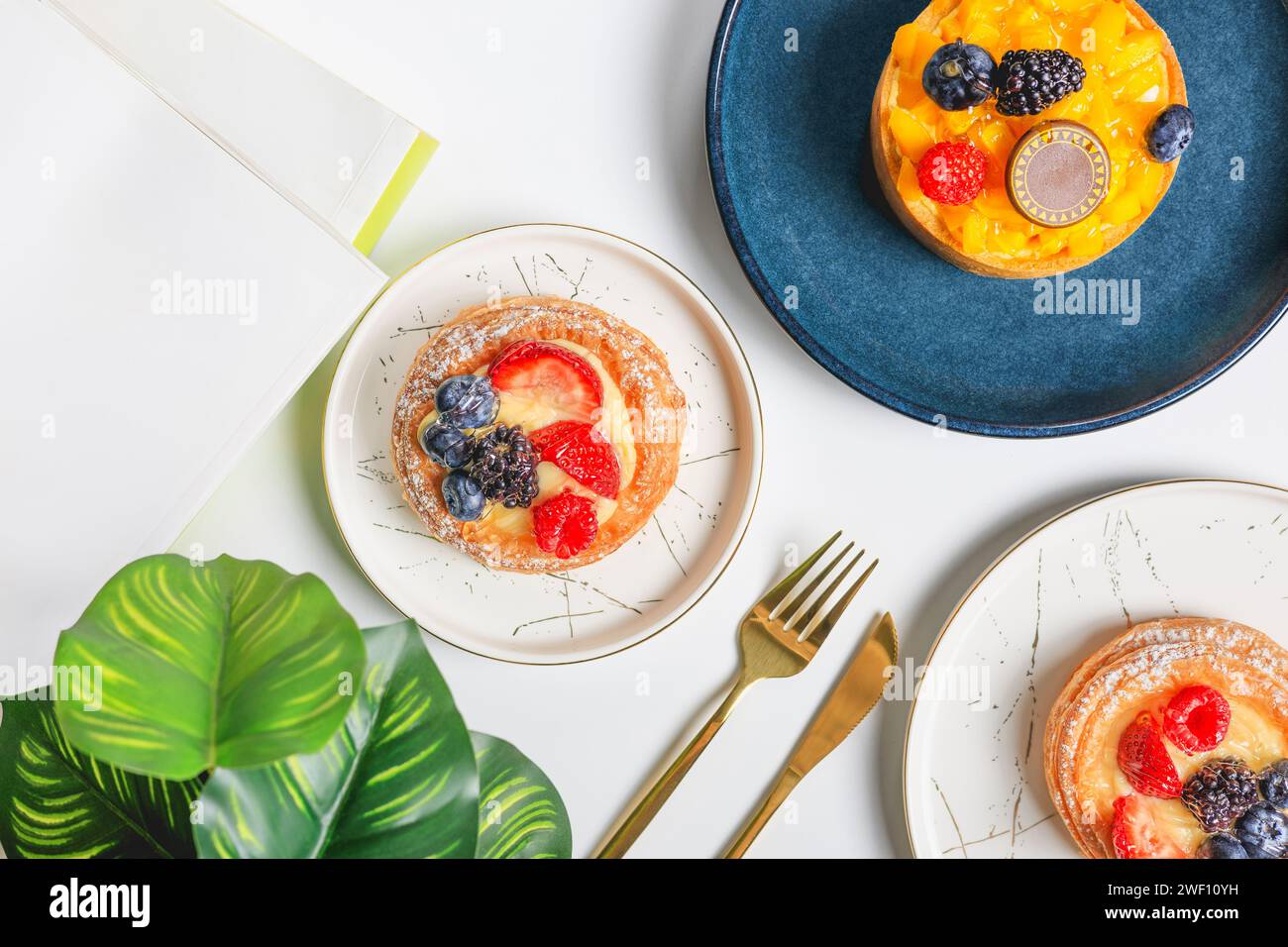 Flat lay composition with delicious berry tartlets on a white ...