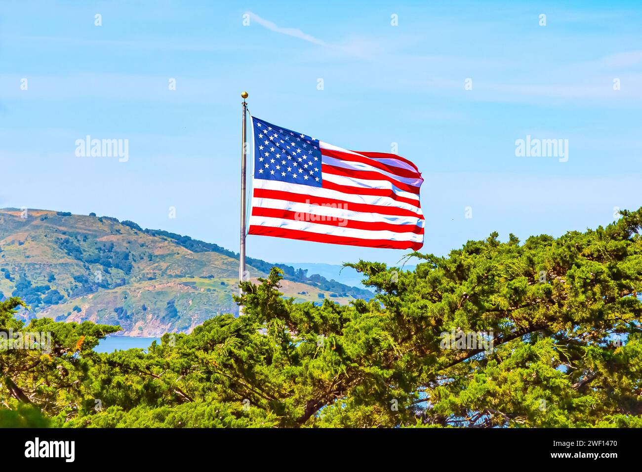 American flag flying on the wind, nature background wit mountains and ...