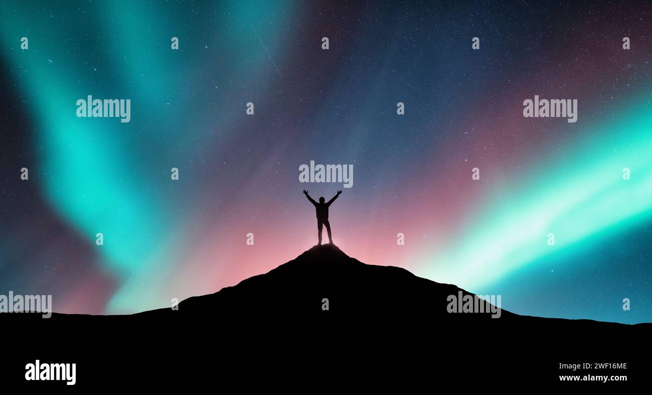 Northern lights and silhouette of a man with raised up arms Stock Photo ...