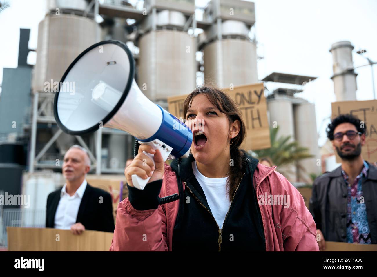 Angry and rebellious woman speaking and protesting with megaphone at ...