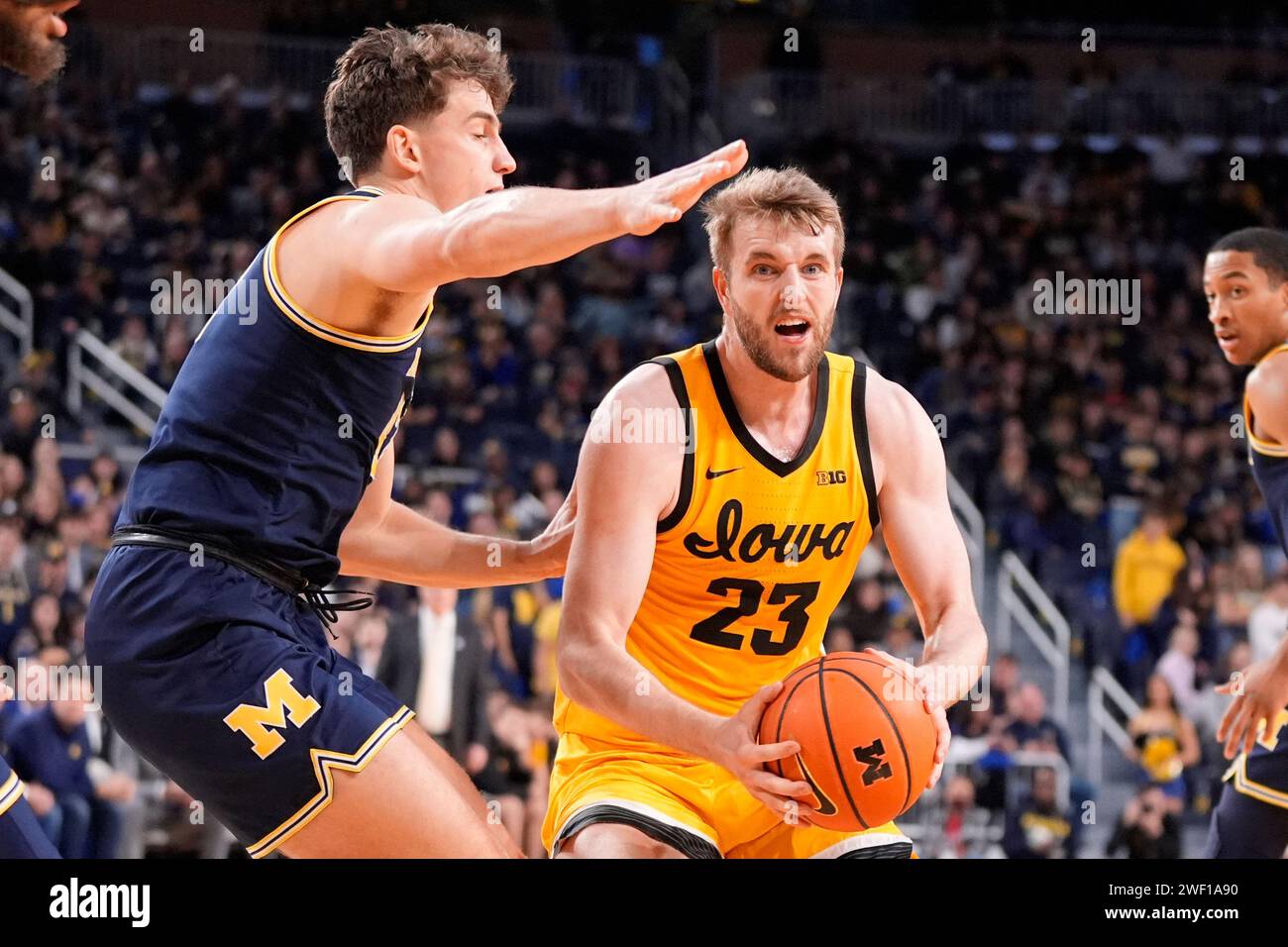 Iowa forward Ben Krikke (23) is defended by Michigan forward Will Tschetter during the first ...