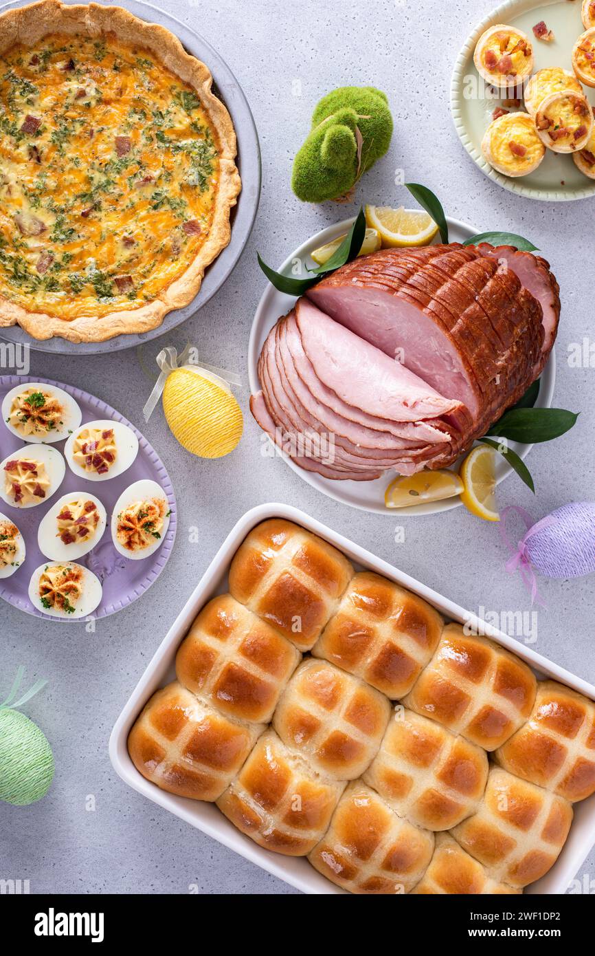 Easter brunch on large table with spiral sliced ham, quiche, deviled ...