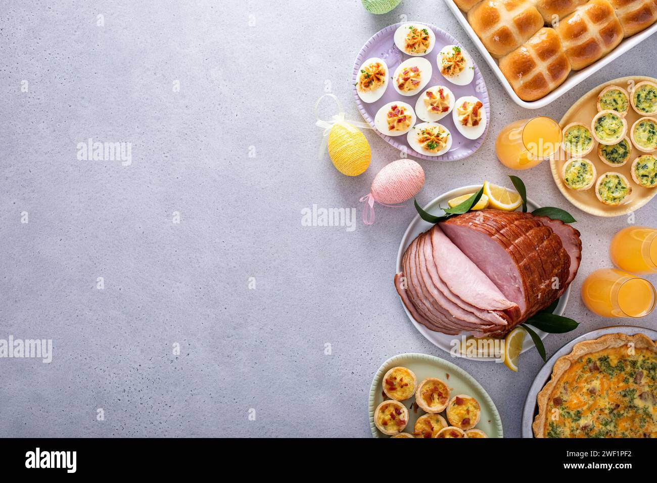 Easter brunch on large table with spiral sliced ham, quiche, deviled ...