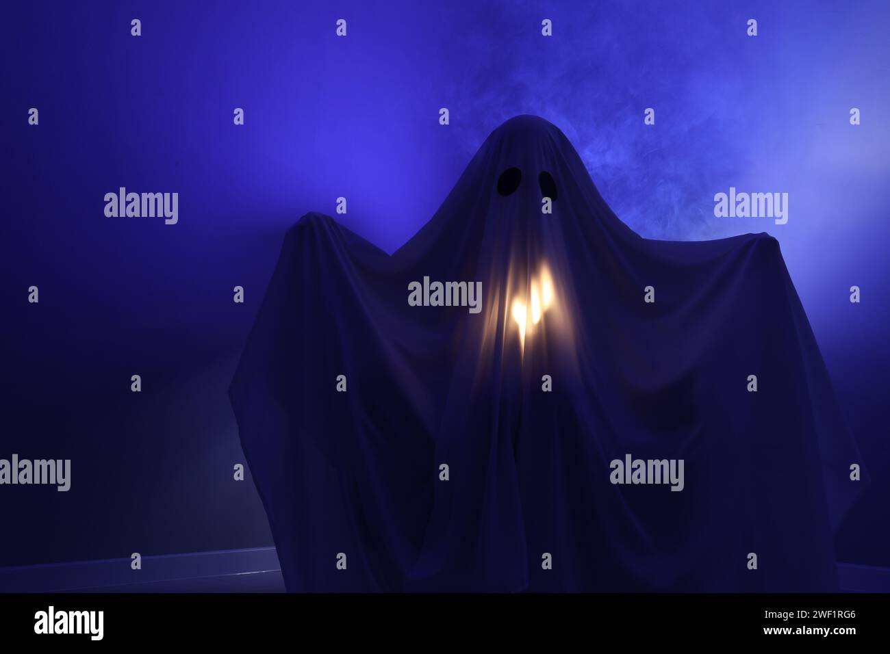 Creepy ghost. Woman covered with sheet in blue light Stock Photo - Alamy