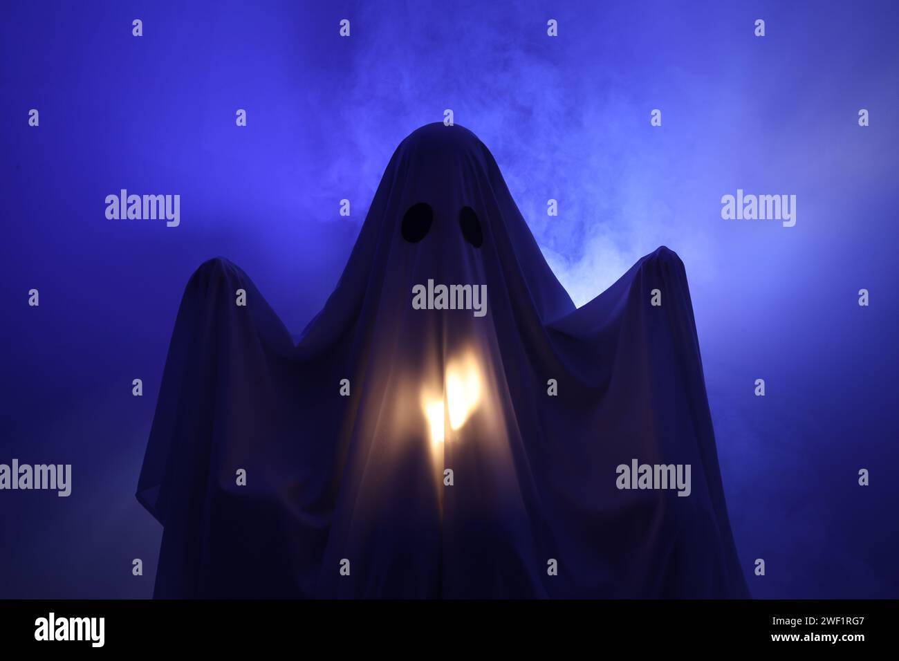 Creepy ghost. Woman covered with sheet in blue light Stock Photo - Alamy
