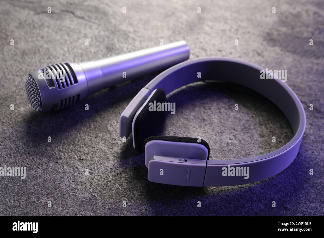 Microphone and headphones on grey textured table, closeup. Sound ...