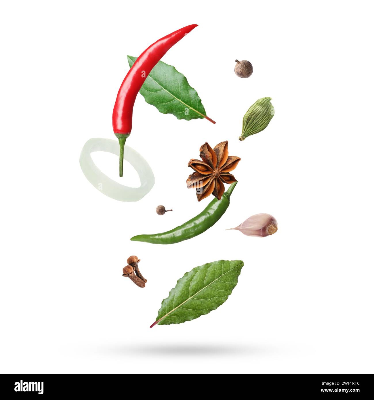 Different aromatic spices falling on white background Stock Photo - Alamy