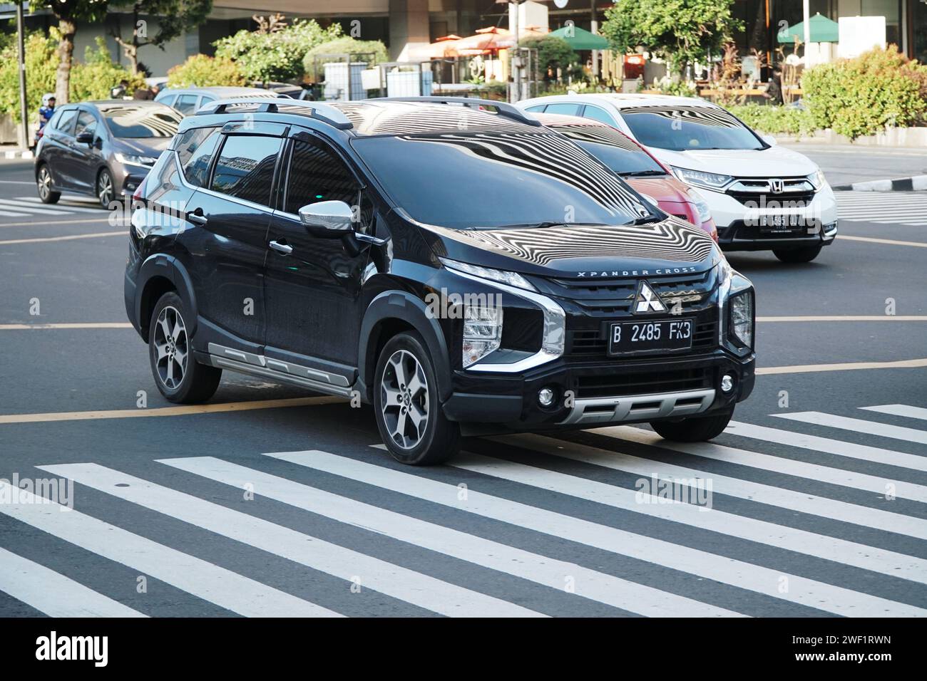 Black Mitsubishi Xpander car,driving in commercial and business area ...