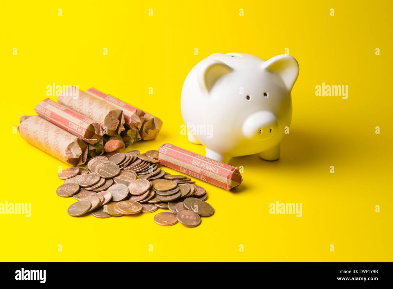American coin rolls with a white piggy bank on a yellow background ...