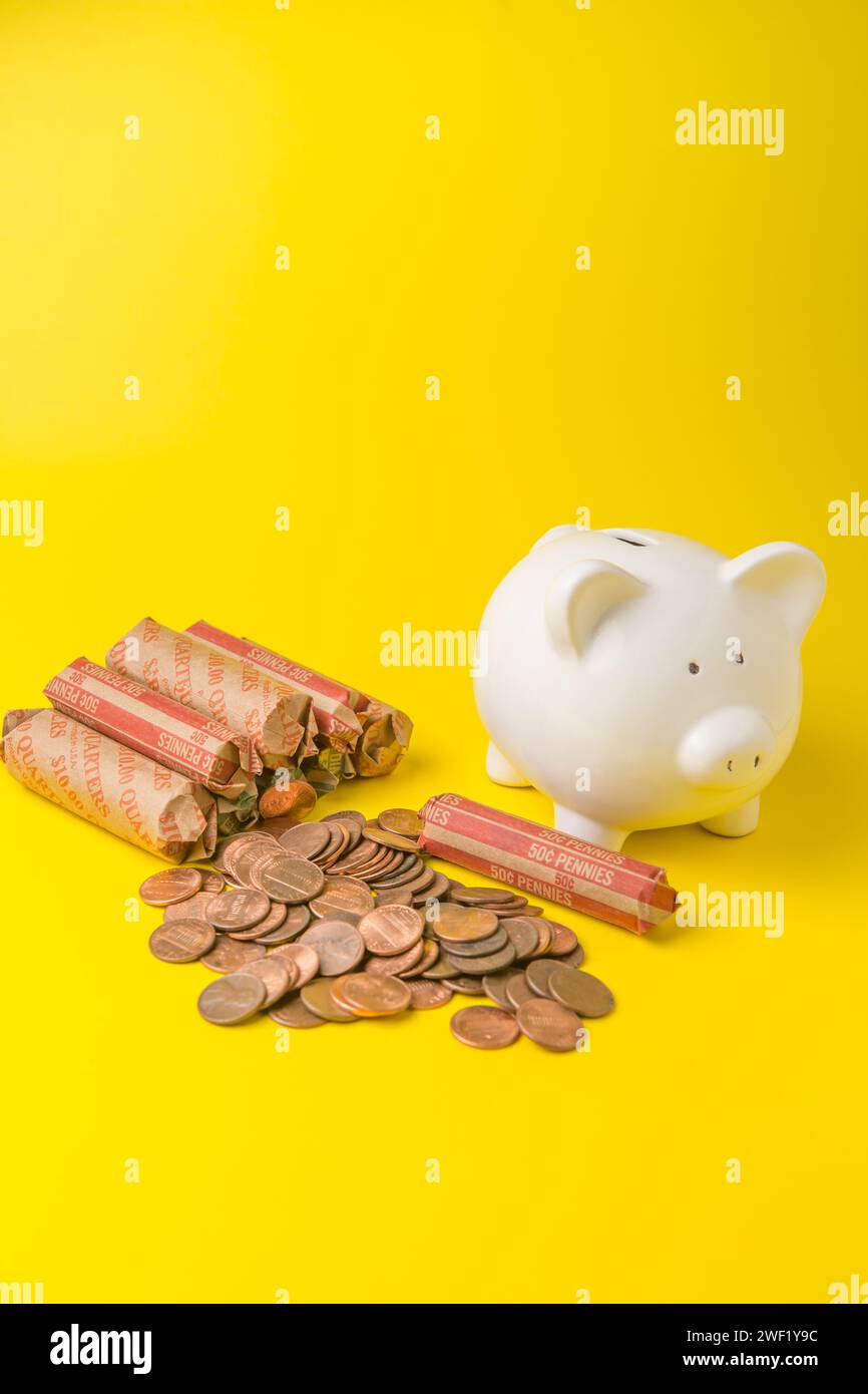 American coin rolls with a white piggy bank on a yellow background ...