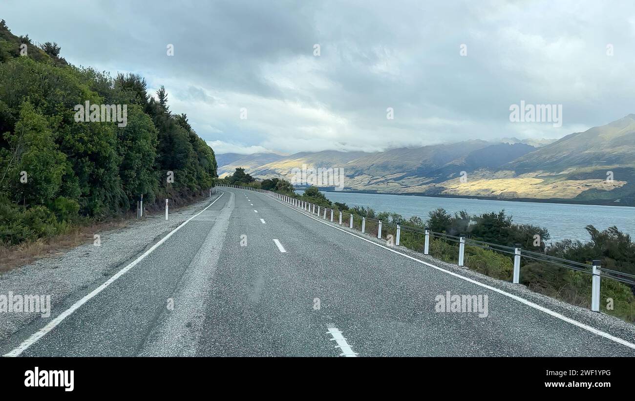 Driving the highway alongside the mountains and the shore of Lake ...