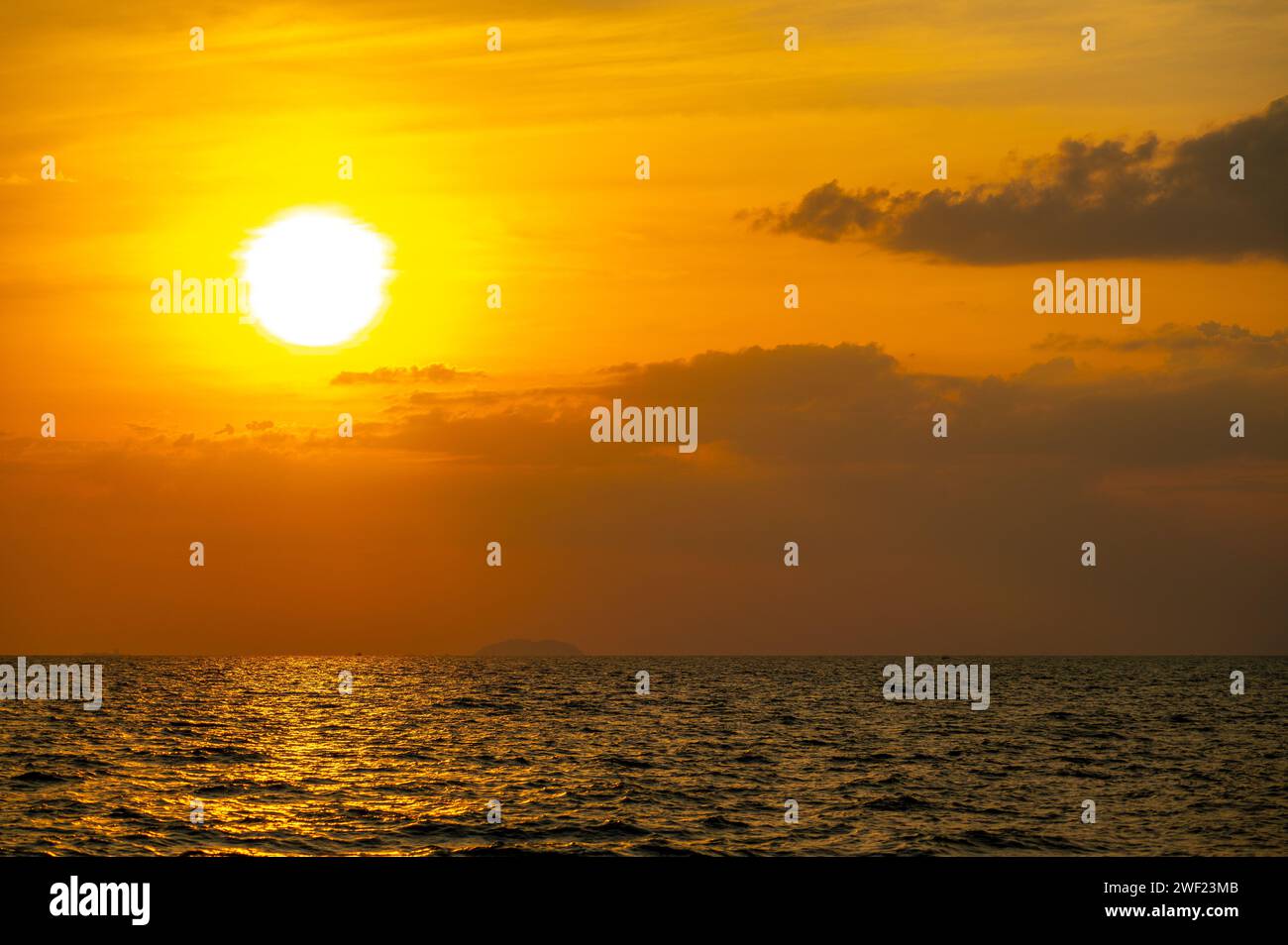 fiery sunset over ocean, with vibrant shades of orange and red painting ...