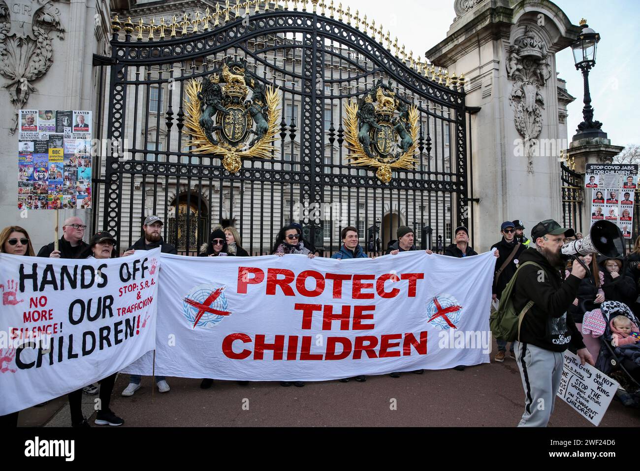 Protesters gather at the gates of Buckingham Palace behind banners ...
