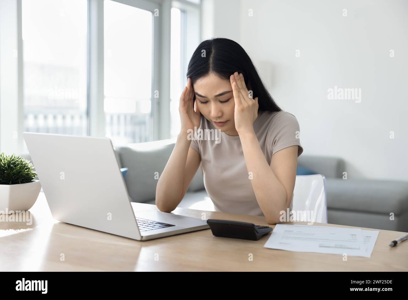 Tired young Asian accountant woman feeling overworked Stock Photo - Alamy