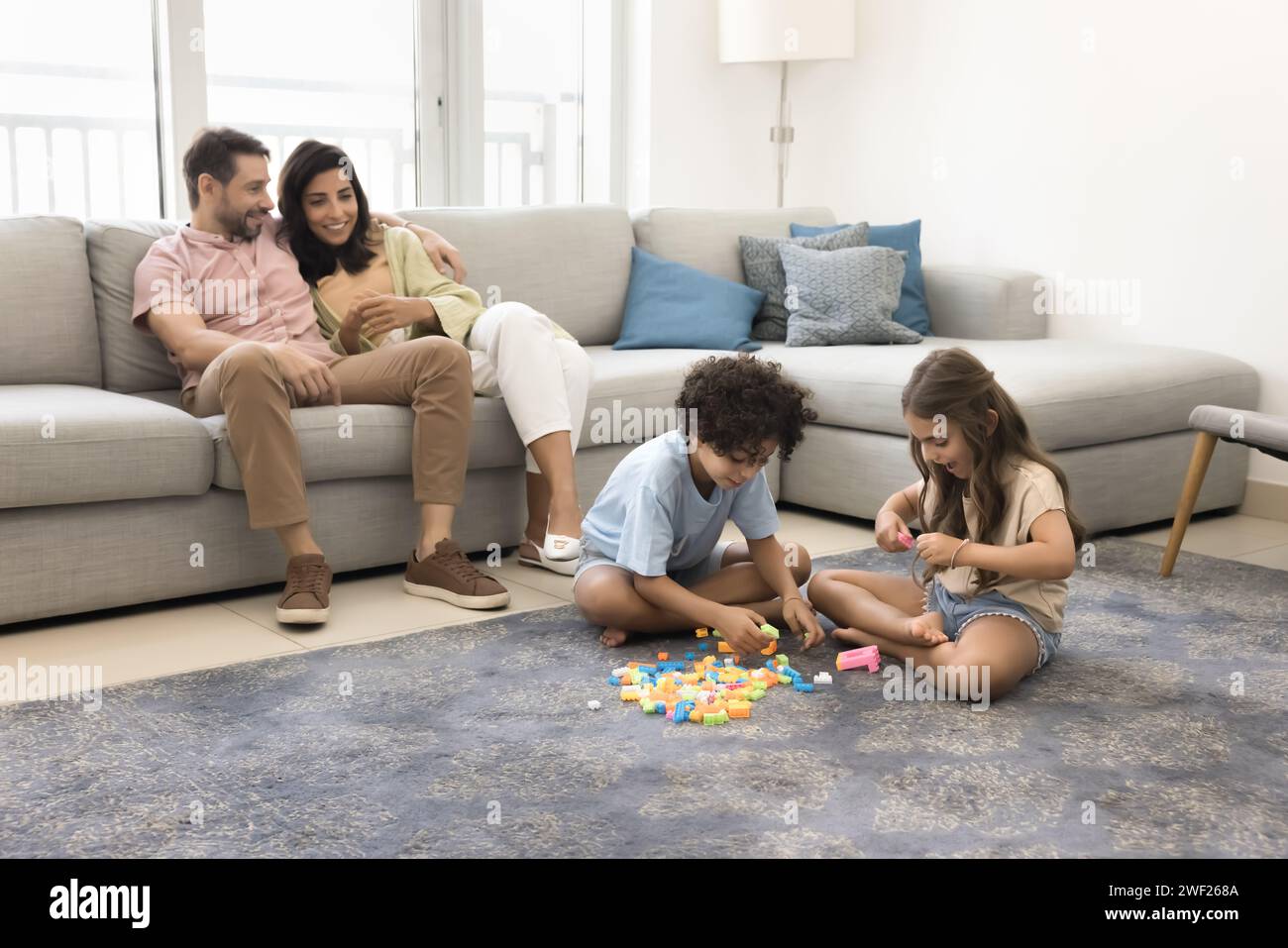 Two cute kids playing with toy blocks on carpeted floor Stock Photo - Alamy