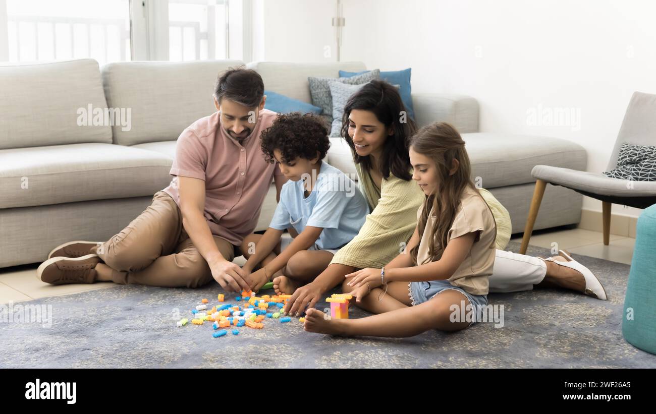 Happy caring parents and two sibling kids constructing towers Stock ...