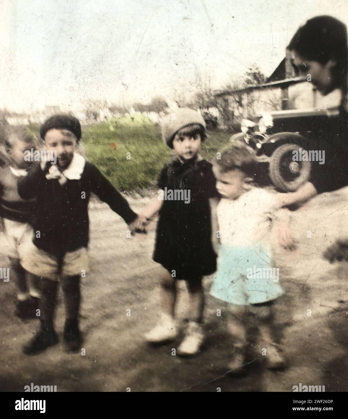 The children are corralled by their mother in a colorized snapshot, ca ...