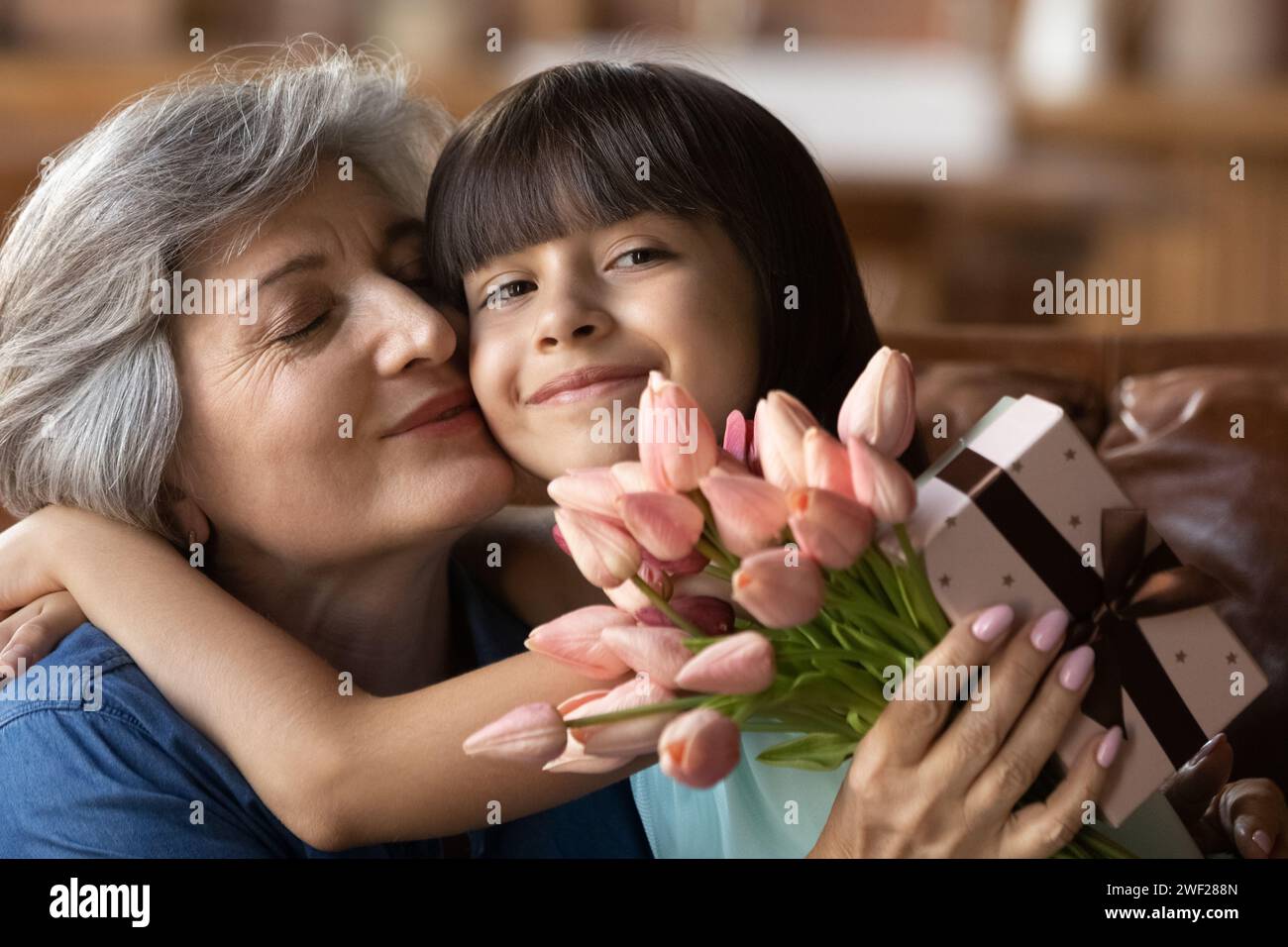 Happy preteen latin girl hug grandma greet with Mothers Day Stock Photo ...