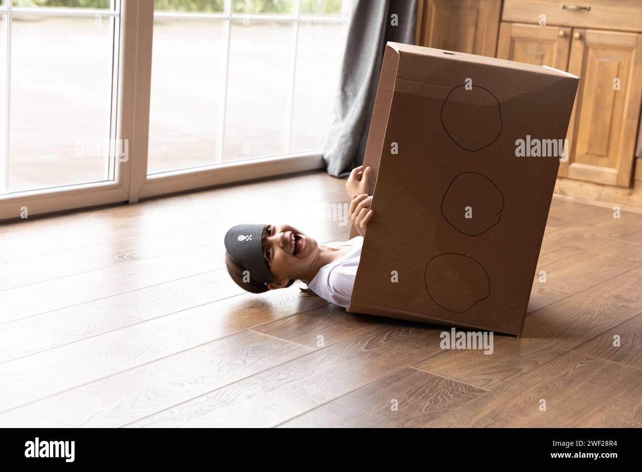 Little girl pretending pirate fall with laughter from cardboard box ...
