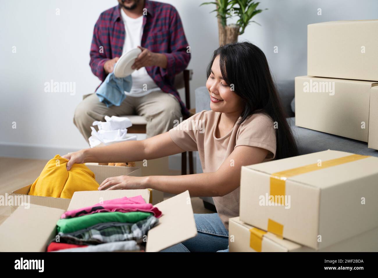 Asian women pack your checked clothes in cardboard boxes for the move ...