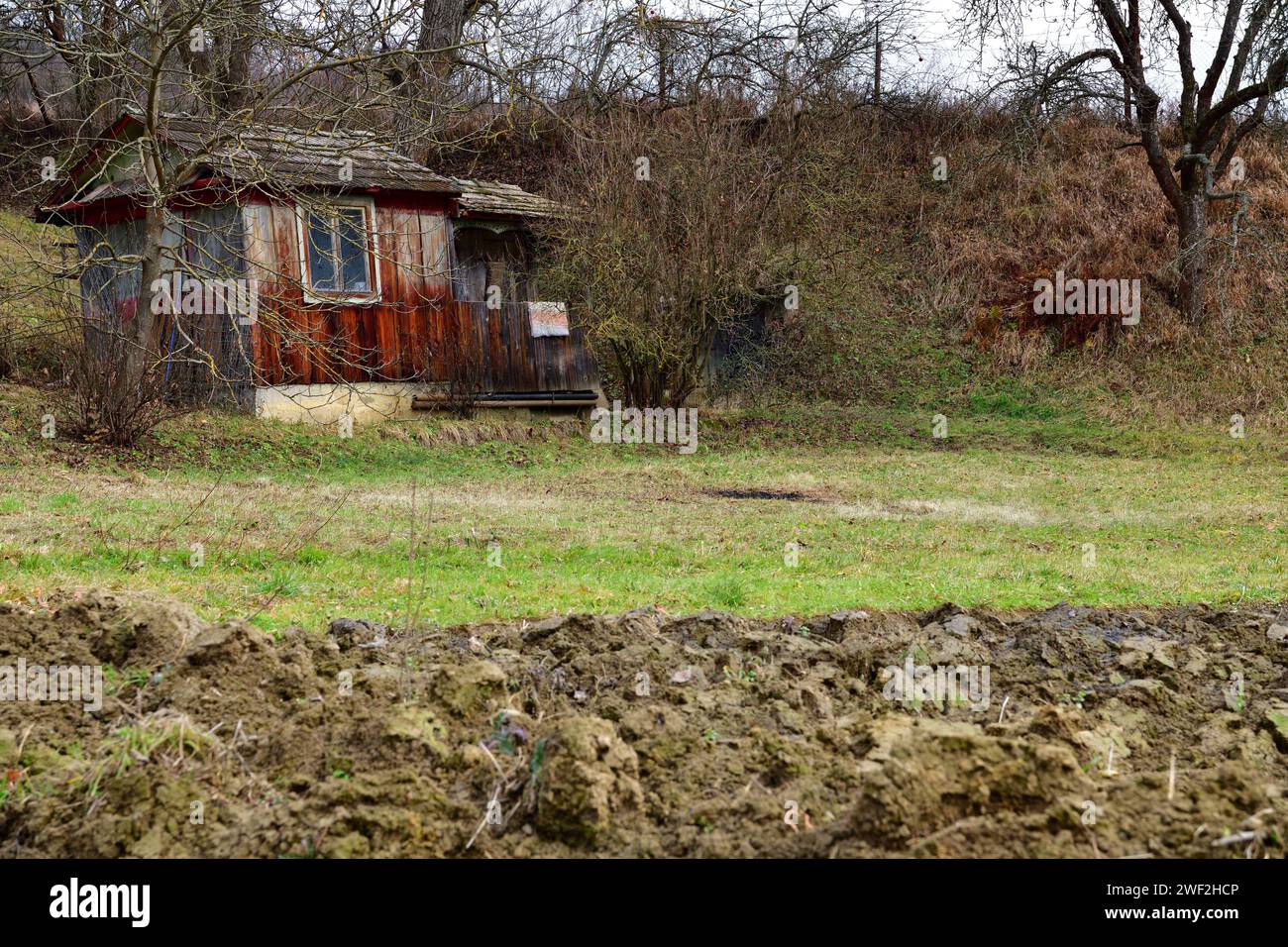 Wooden farm house with a field for planting in the village ...