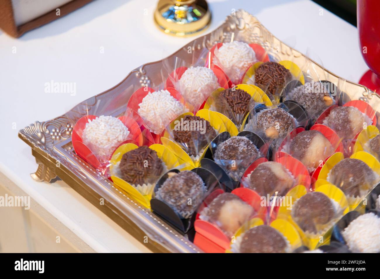 Chocolates and candy balls displayed in elegant plastic containers ...