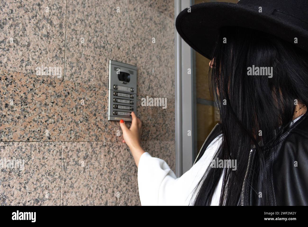 Side view of unrecognizable woman wearing a hat pushing the button of ...