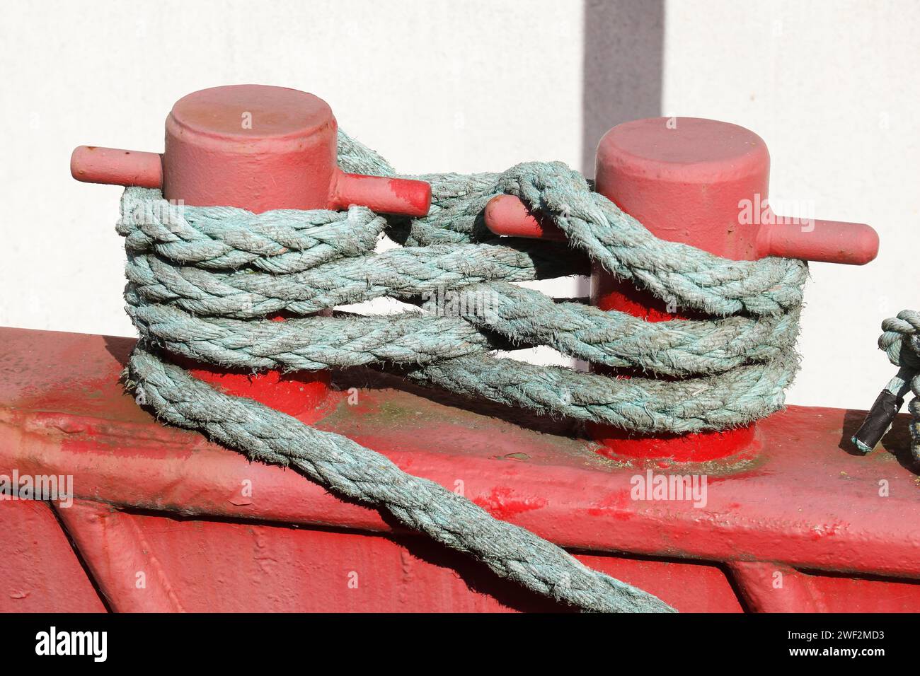 Red ship's bollard wrapped with ship's rope, mooring line, Germany ...