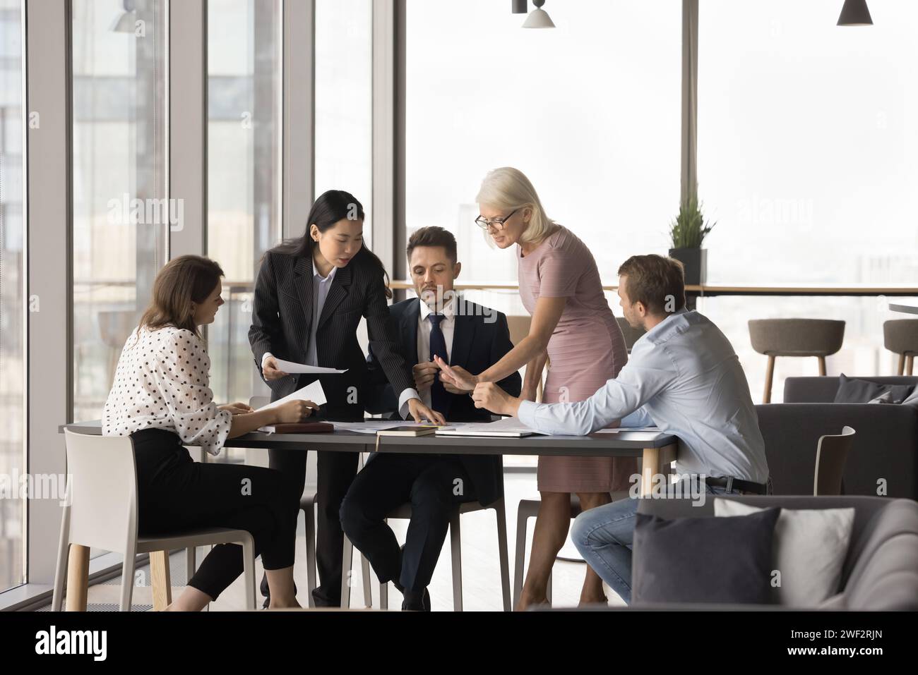 Busy diverse managers giving paper documents to boss for signing Stock ...