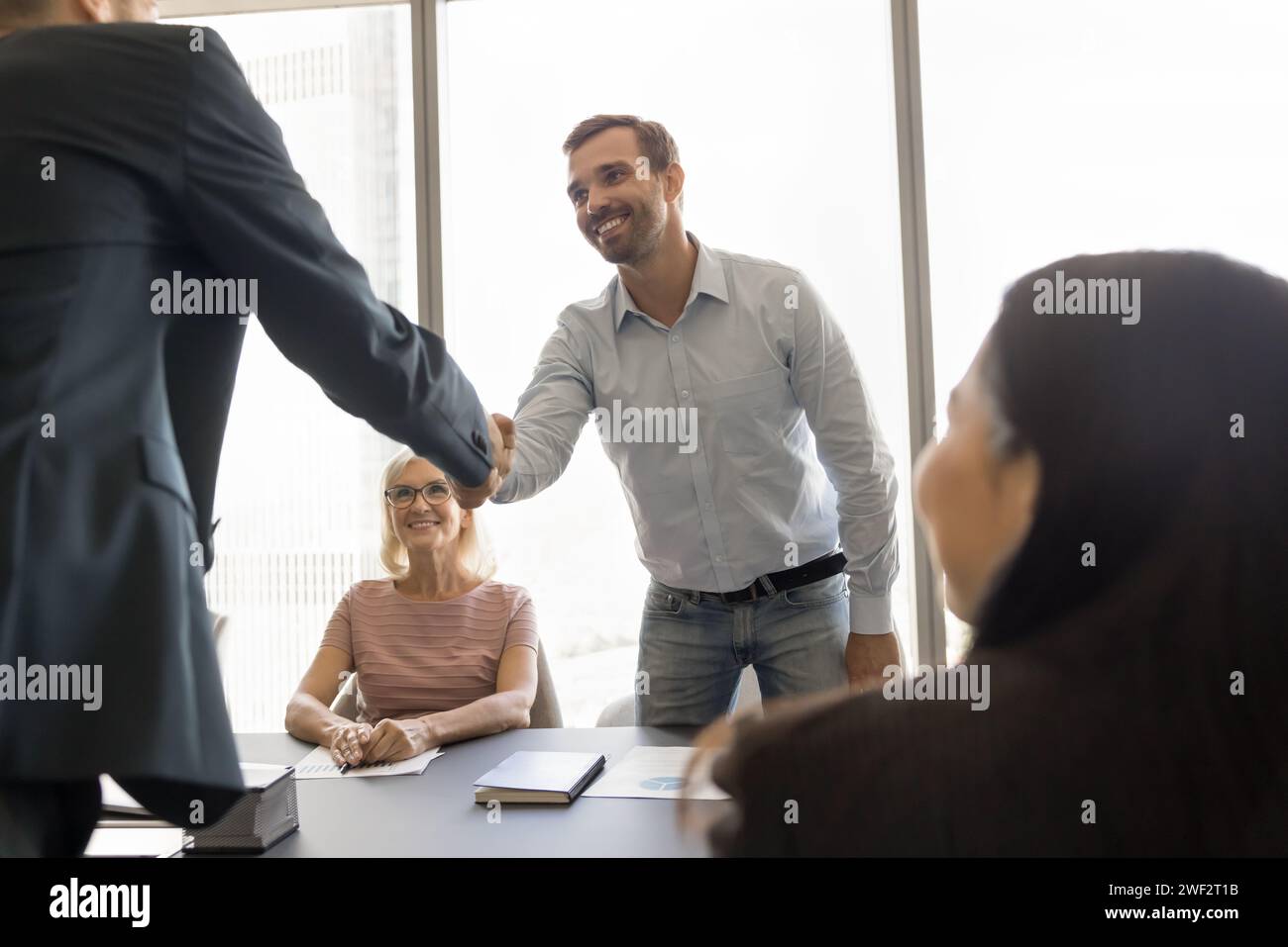 Happy managers men giving greeting handshake on team meeting Stock ...