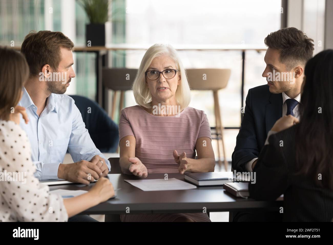 Confident serious elder female boss motivating team for teamwork Stock ...