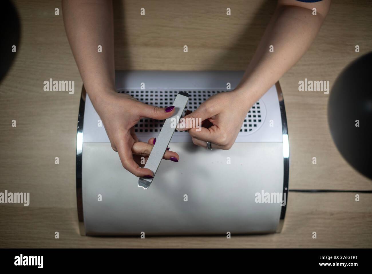 Portrait of female hands while manually filing her own nails, Close up ...