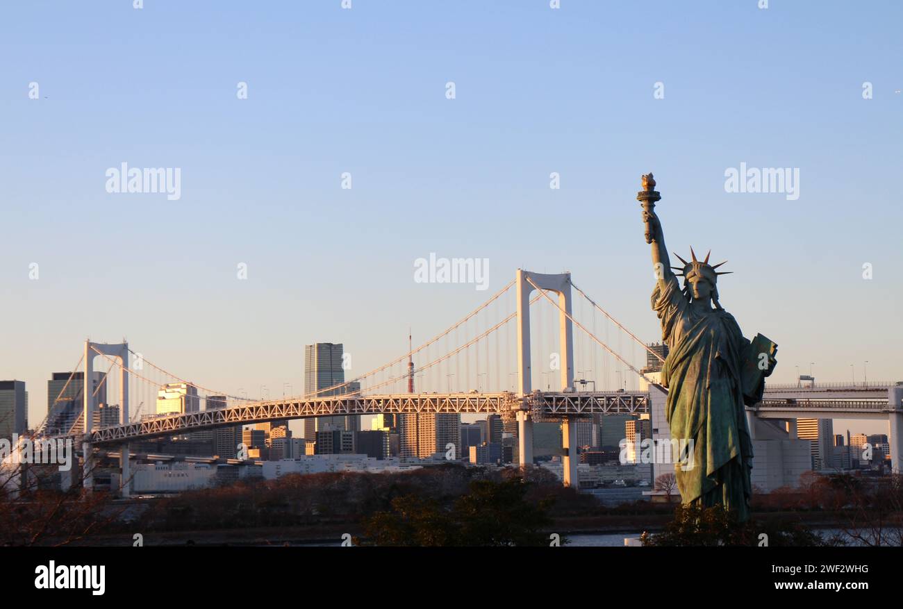 Rainbow Bridge and Statue of Liberty in dusk viewed from Odaiba Seaside ...
