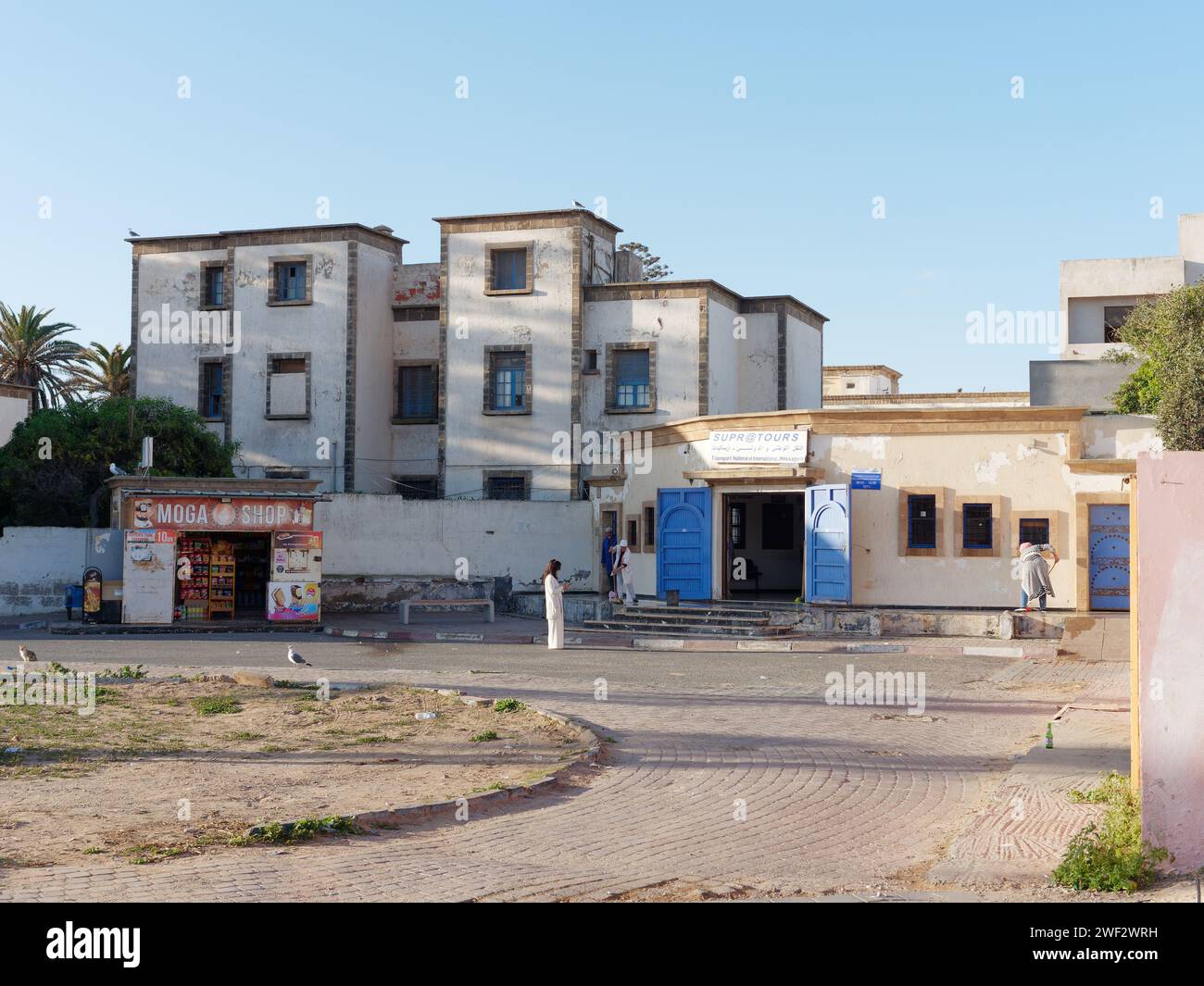 Staff members sweeping outside Supratours bus station in Essaouira ...