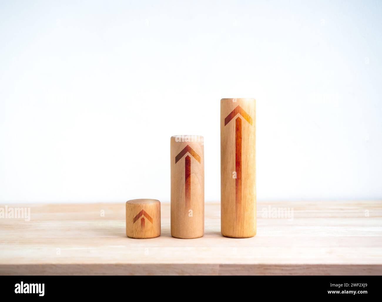 Rising up arrows on round wooden sticks as business graph steps ...
