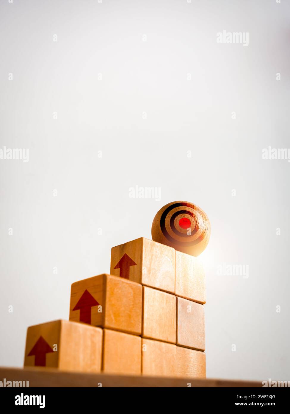 Big target icon on wooden sphere on top of cube blocks bar graph chart ...