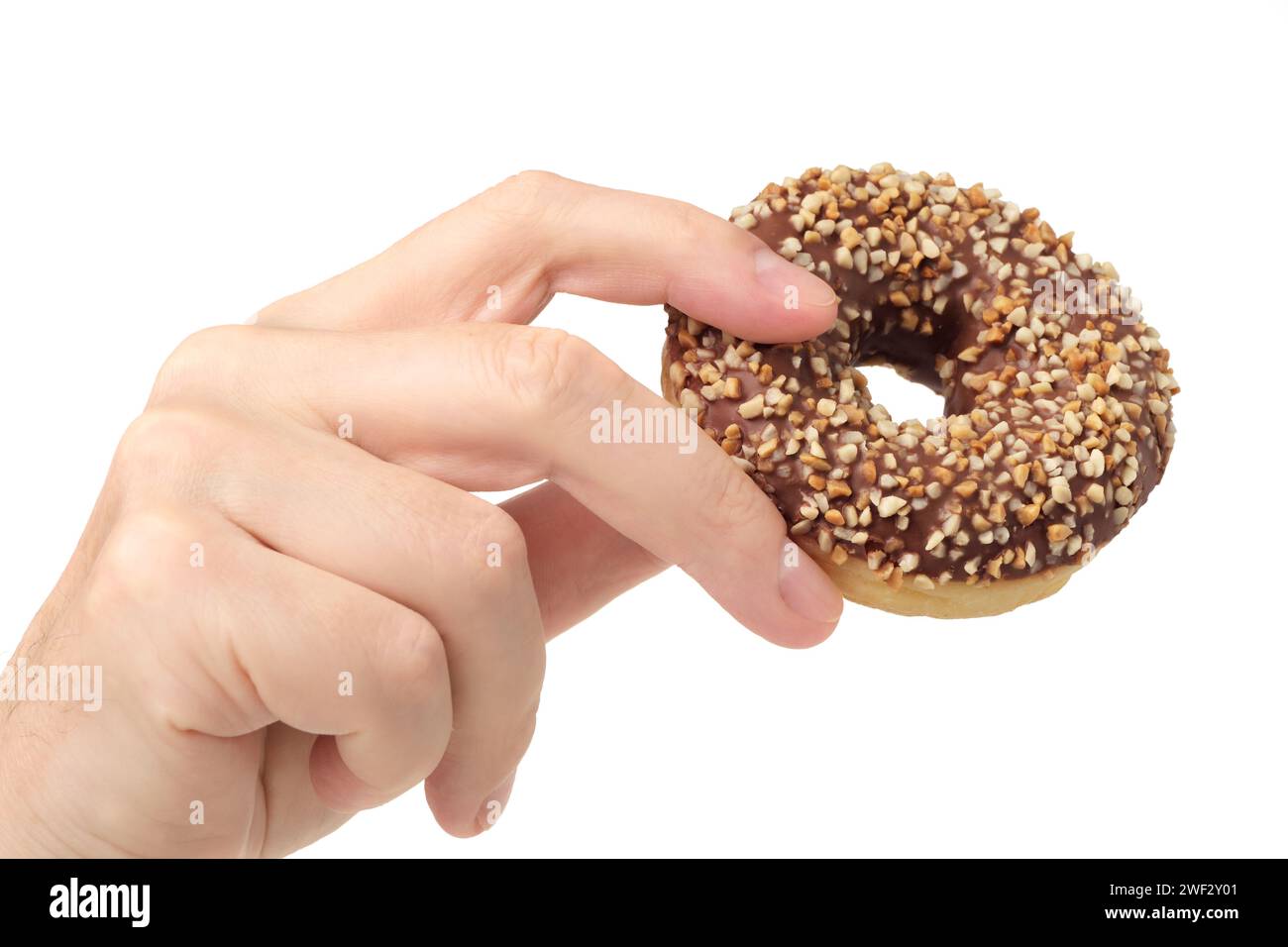 Human hand holding chocolate and crushed nuts donut, side view ...