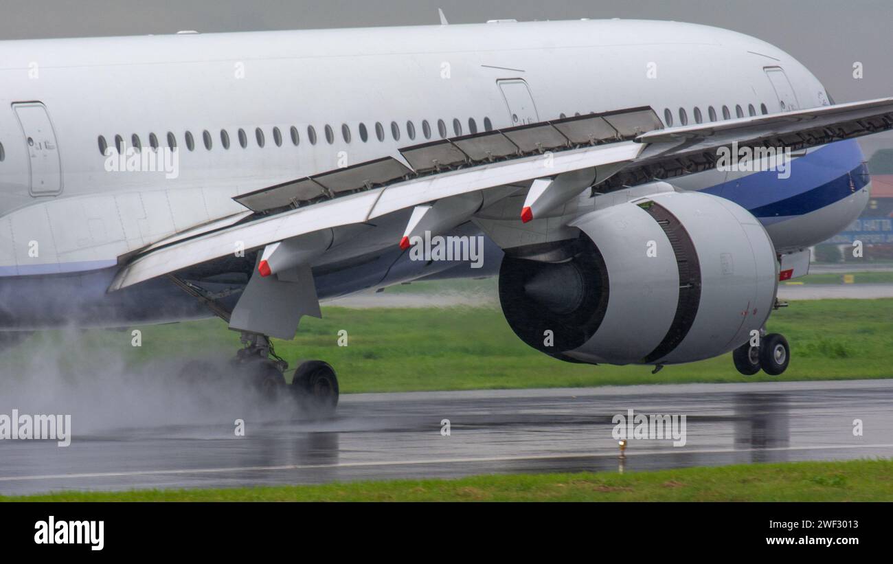 Plane landing in the wet runway in rainy day Stock Photo - Alamy