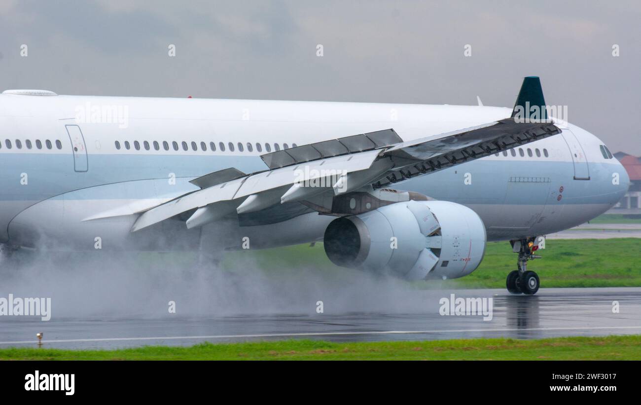 Plane landing in the wet runway in rainy day Stock Photo - Alamy