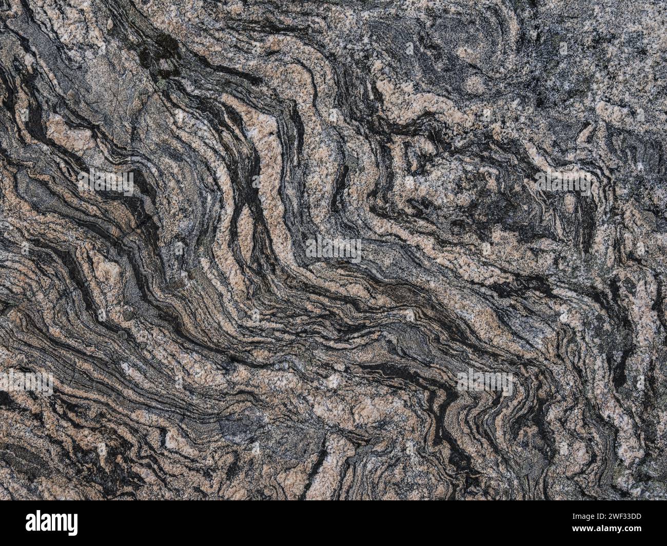 This image captures the complex textures and layers of a swirled rock ...