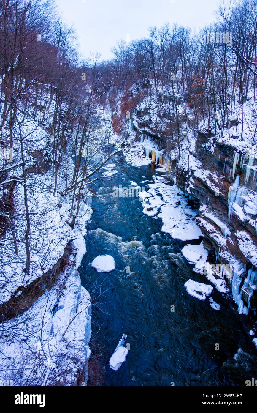 Frozen stream in forest with buildings on banks Stock Photo - Alamy