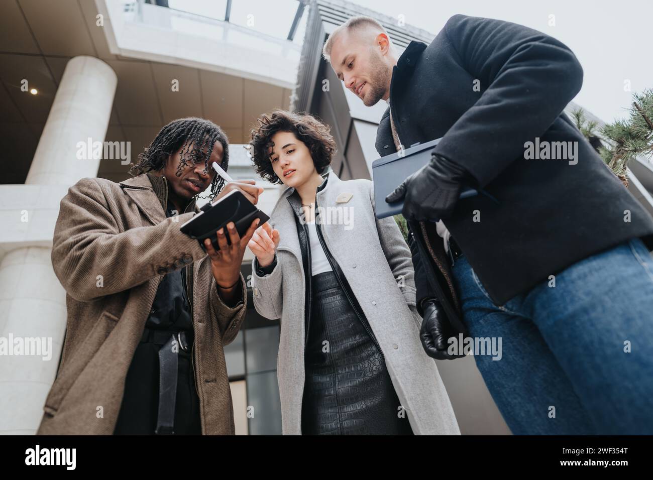 Three multicultural business partners engage in a friendly discussion ...