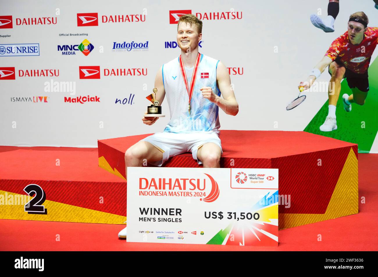 Denmark's Anders Antonsen celebrates on the podium after defeating ...